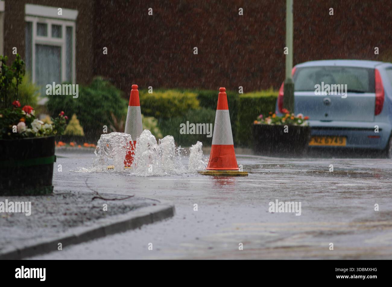 Surface water gushing from road drain during heavy rainfall, drain ...