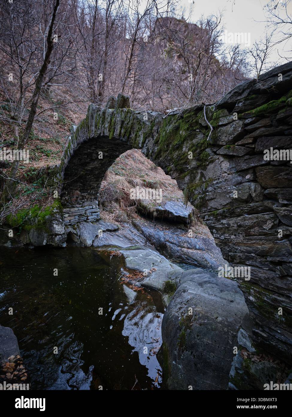 Historic dry stone arch bridge over the stream below cratolo, onsernone ...