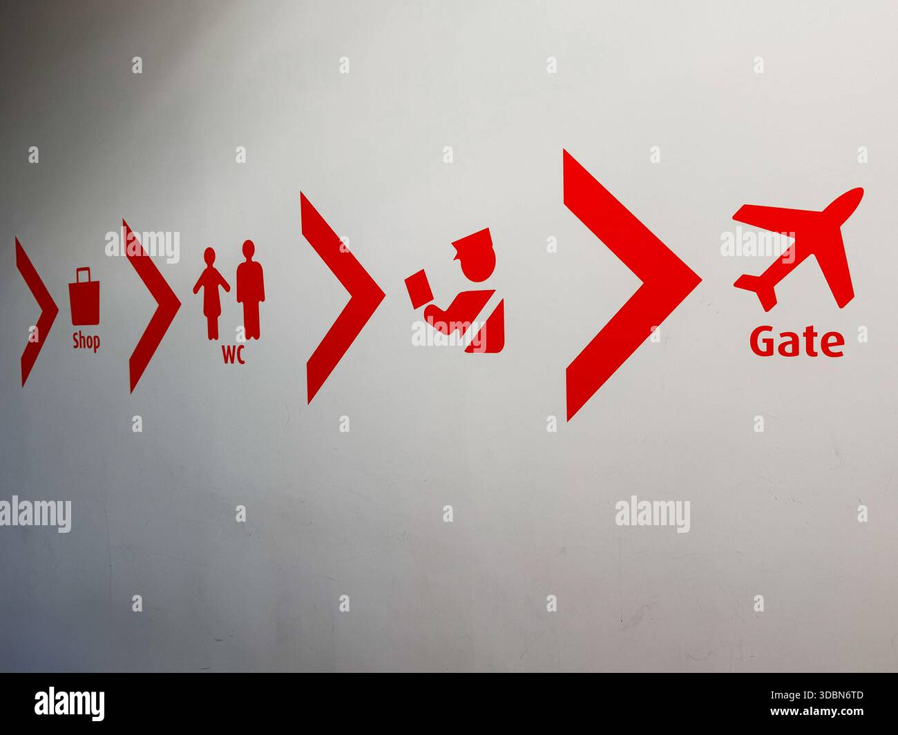 Colorful red airport signage guides travelers from shop and restrooms ...