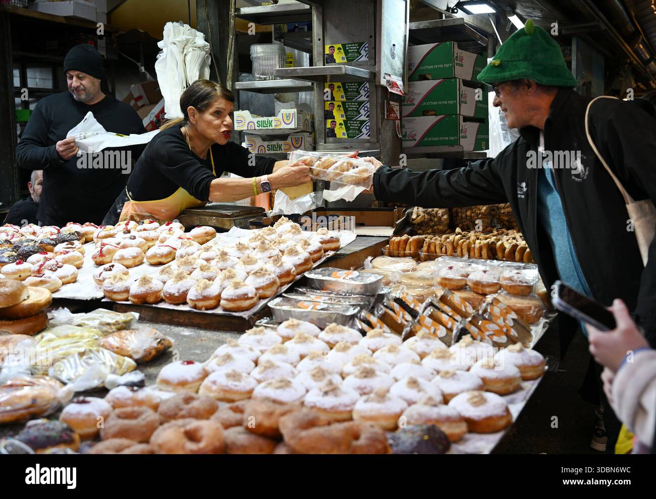 A baker sells jelly filled donuts, sufganiyot, on the fourth day of the ...