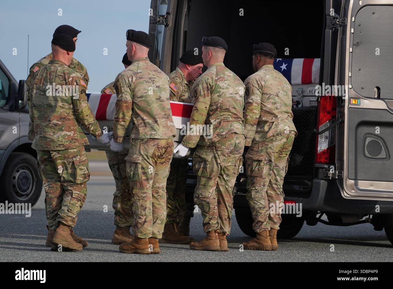 An Army carry team moves the flag-draped transfer case with the remains ...