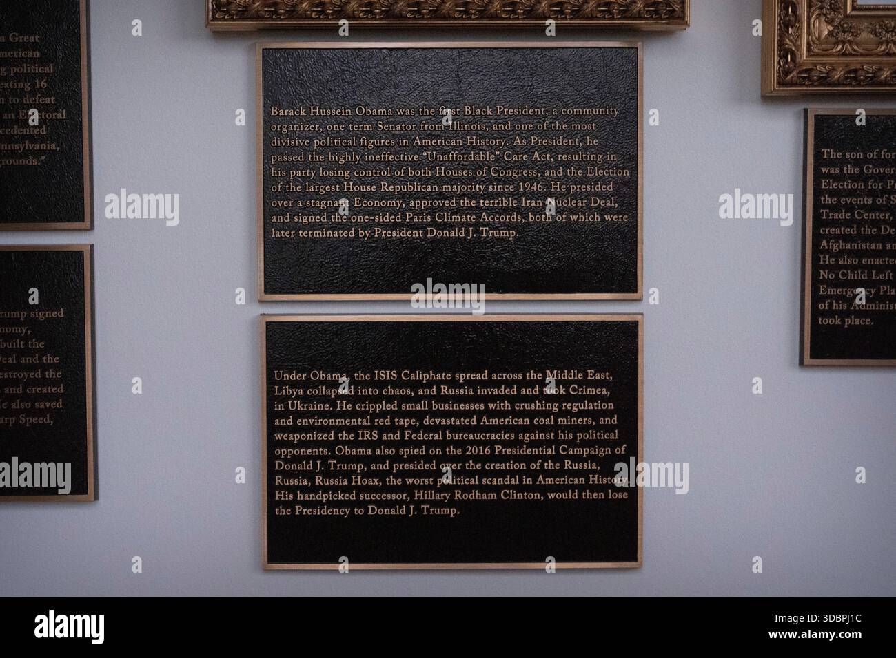 Plaques of explanatory text are seen beneath a framed portrait of former President Barack Obama ...