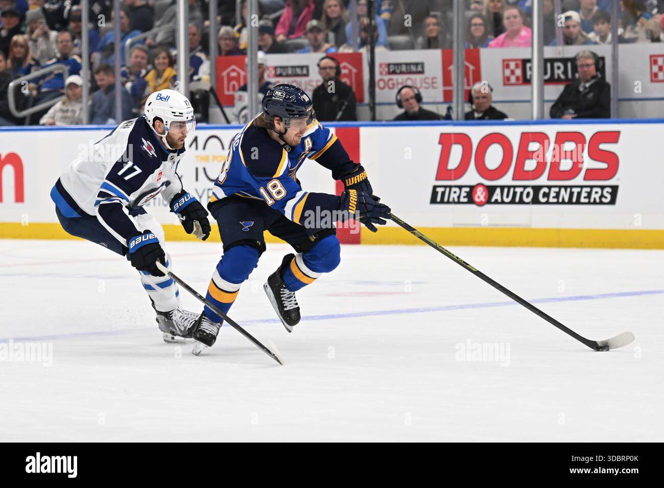Winnipeg Jets center Adam Lowry (17), left, pressures St. Louis Blues ...