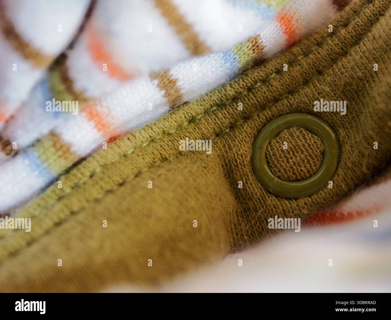 Close up shot of a white fabric with line pattern and an olive green ...