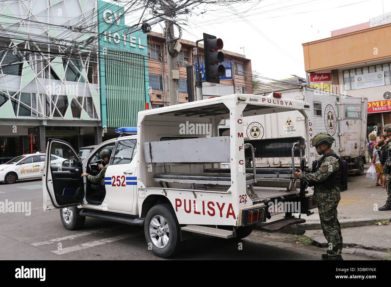 Police guard a budget hotel in downtown Davao City, southern ...
