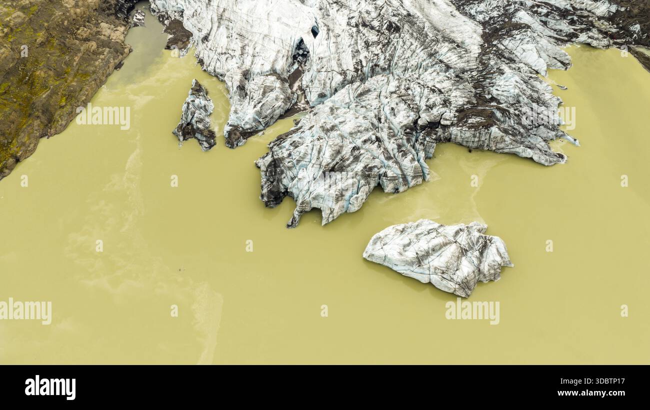 Aerial view of glacial ice meeting the milky waters of the lagoon ...