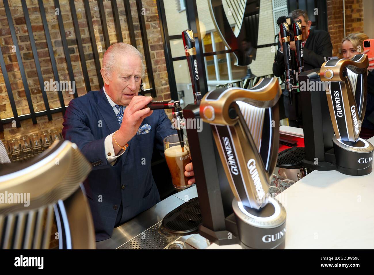 King Charles III pours a pint of Guinness during his visit to the ...