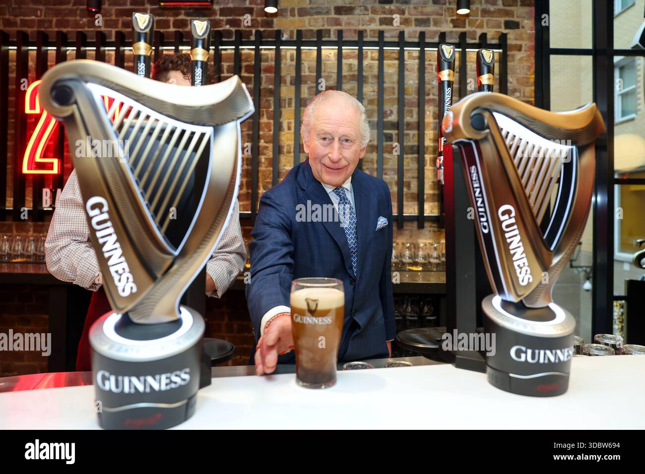 King Charles III pours a pint of Guinness during his visit to the ...