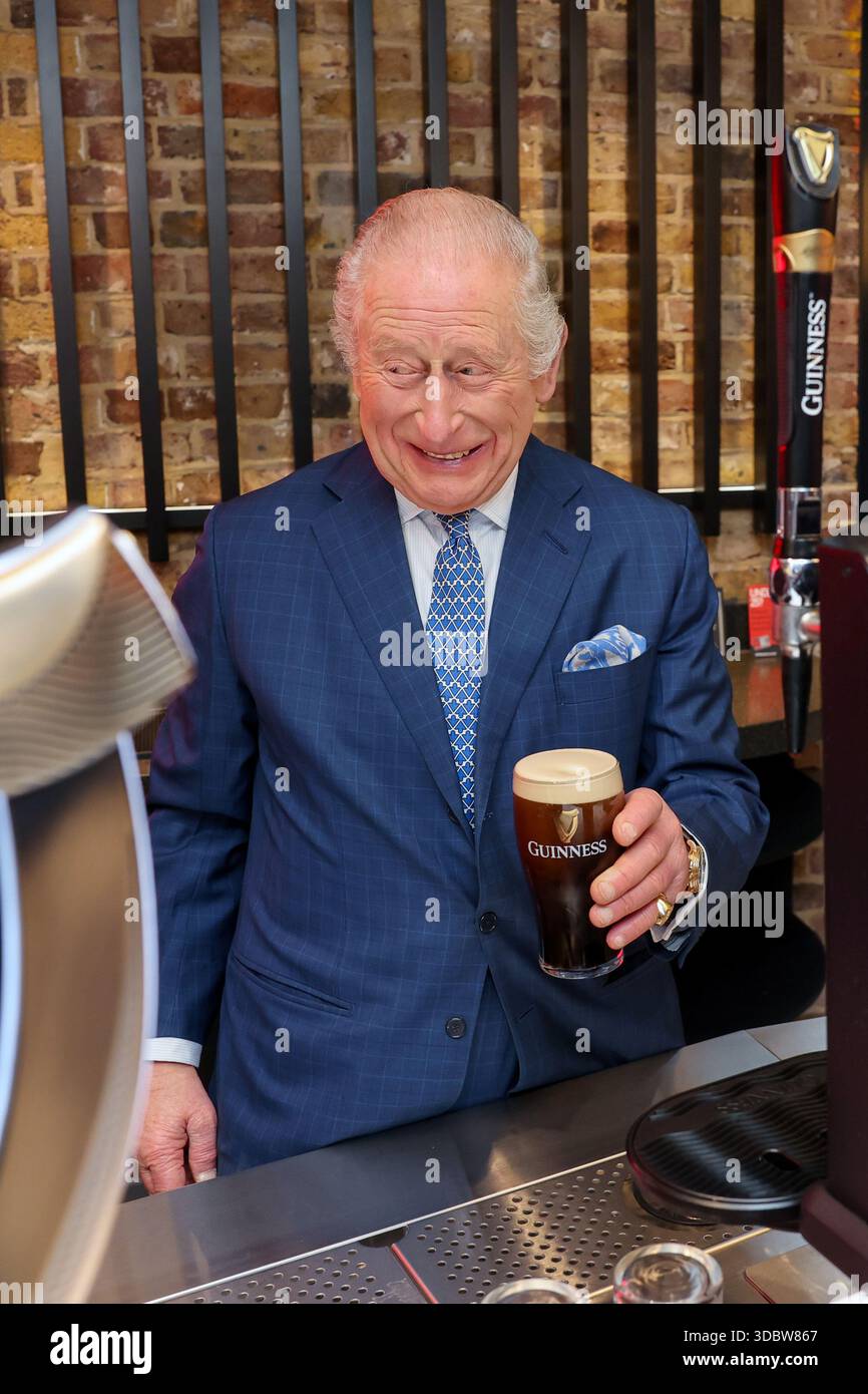 King Charles III pours a pint of Guinness during his visit to the ...