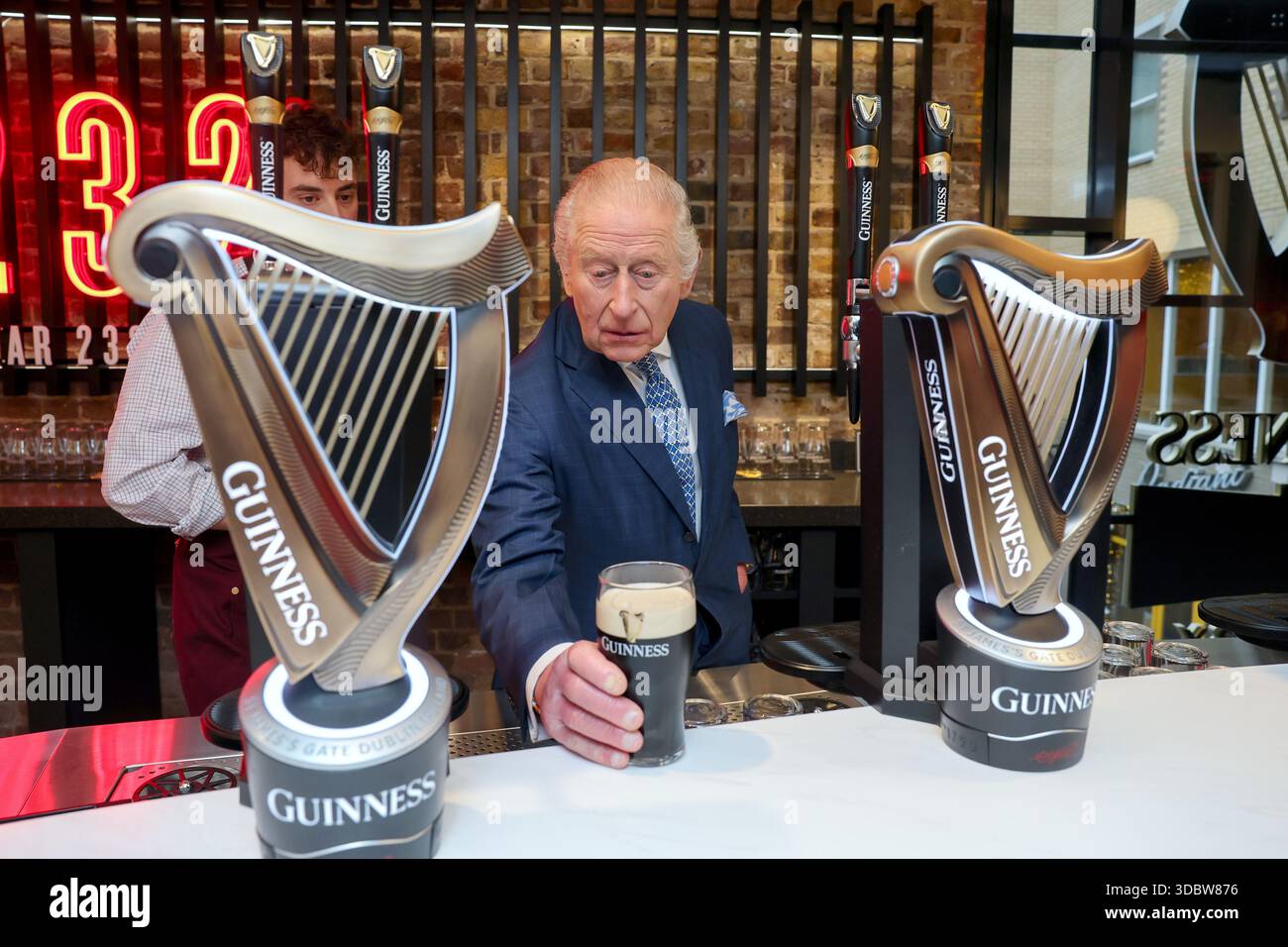 King Charles III pours a pint of Guinness during his visit to the ...
