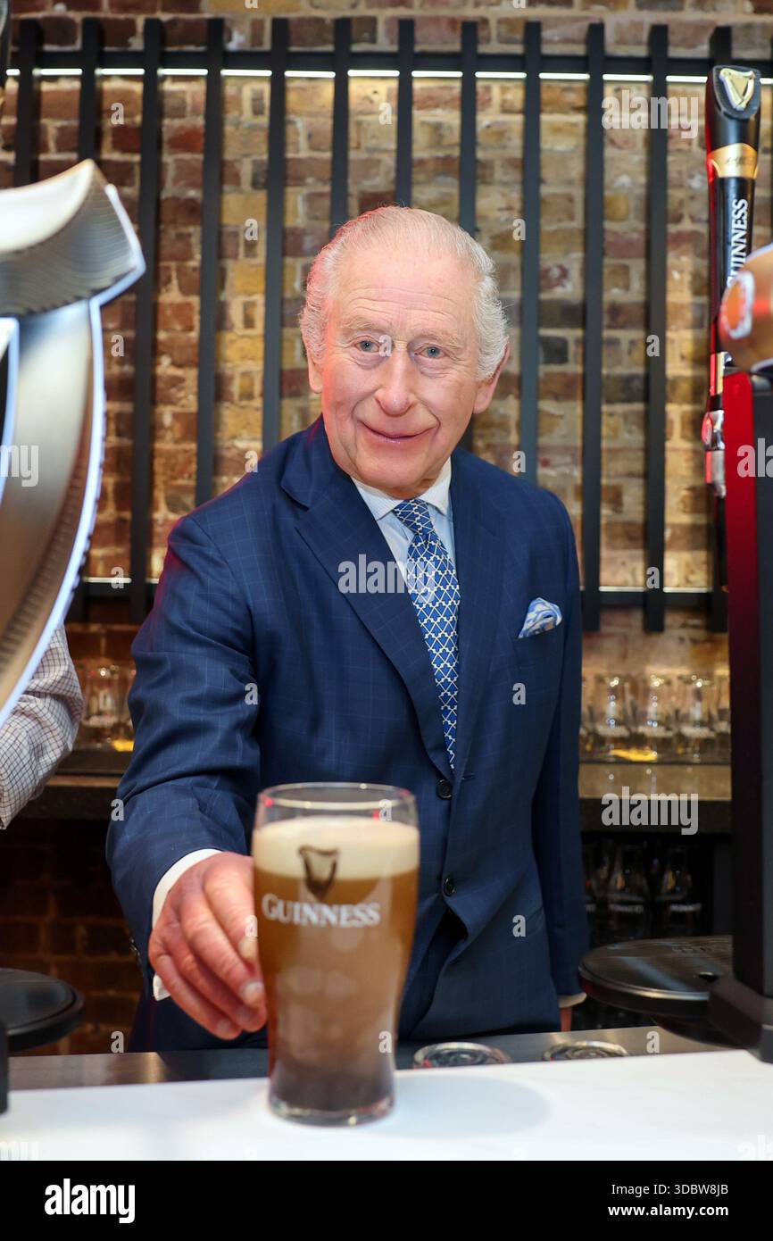 King Charles III pours a pint of Guinness during his visit to the ...