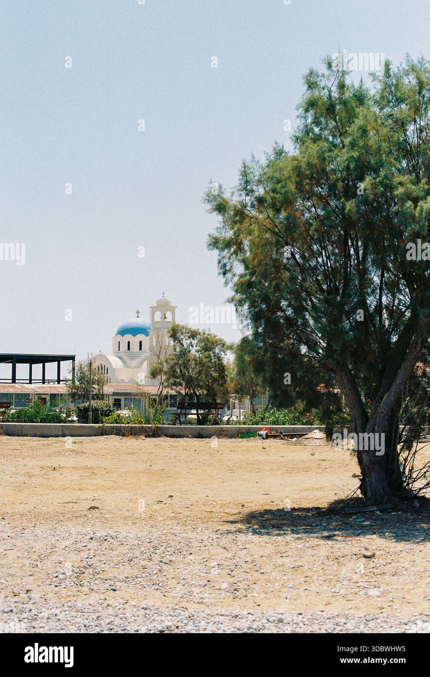 Greek Orthodox church with blue dome behind tamarisk tree and empty ...