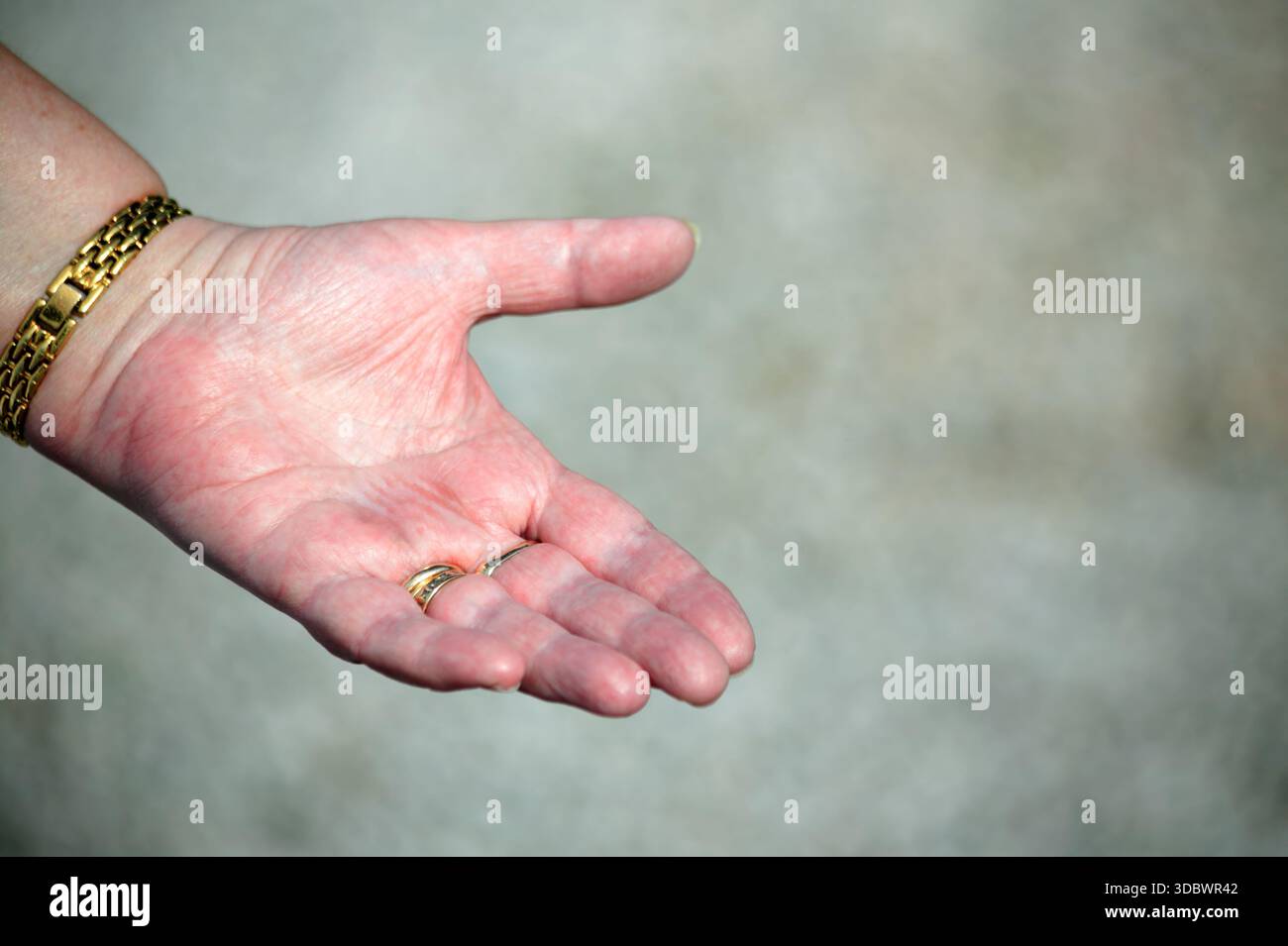 Old aged female pensioner with outstretched hand asking for help and ...