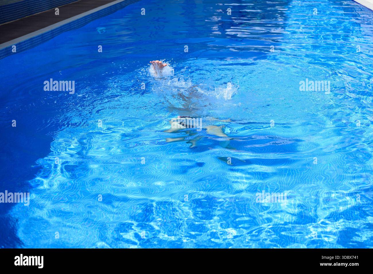 Drowning person's hands reaching for above water in swimming pool ...