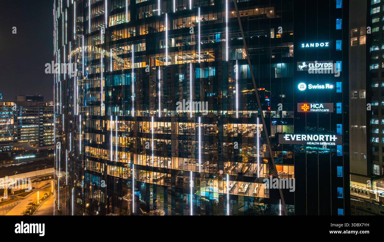 Aerial view of a modern skyscraper illuminated with warm interior ...