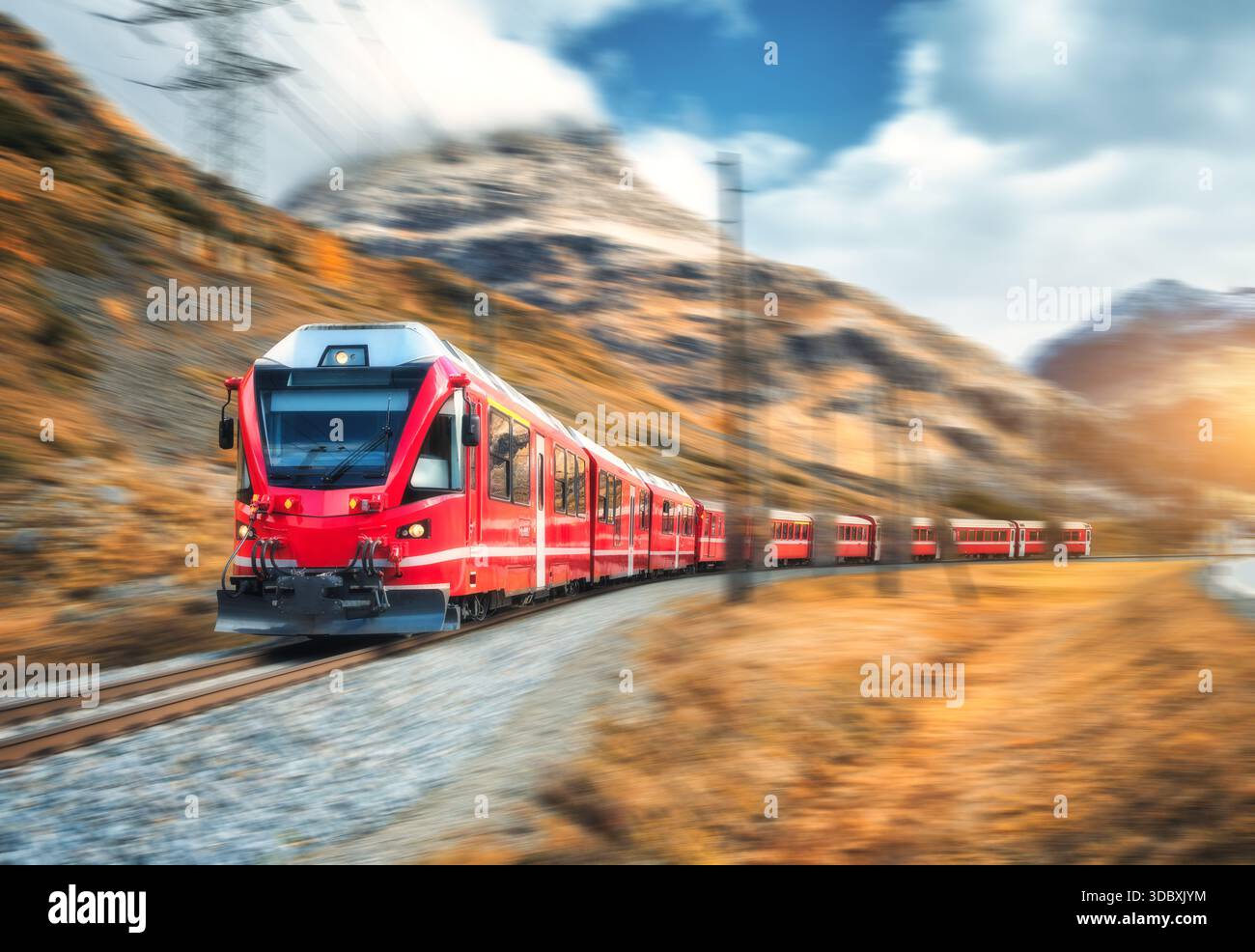 Red modern passenger train is moving on railway in swiss alps Stock ...