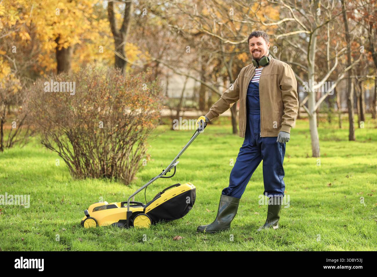 Person using electric lawn mower hi-res stock photography and images ...