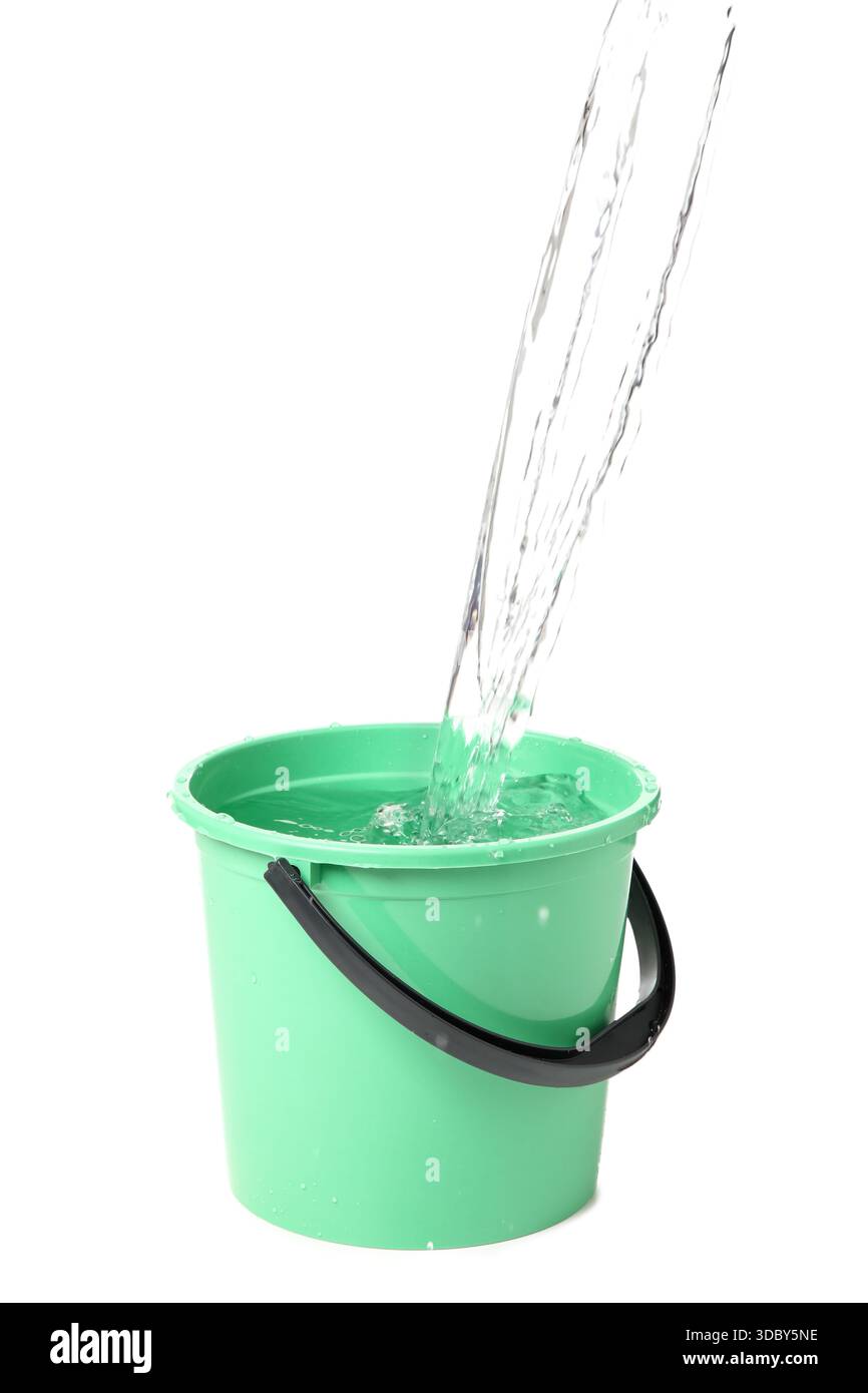 Pouring of water into green bucket on white background Stock Photo - Alamy