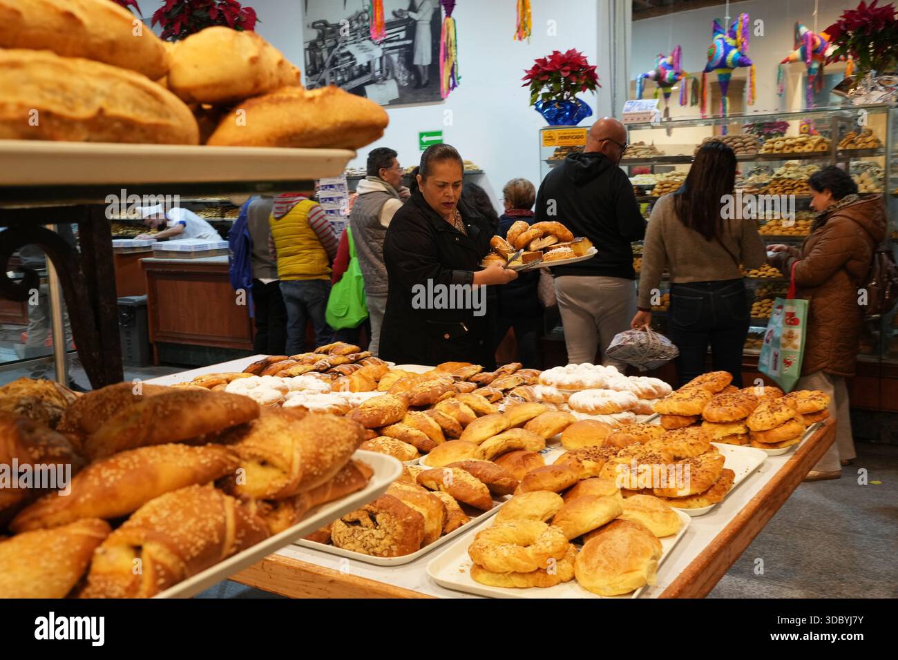 People buy pastries at a bakery in Mexico City, Thursday, Dec. 18, 2025 ...