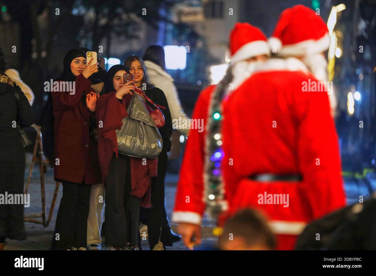 Bystanders take photos of two men dressed as Santa Claus ahead of the ...