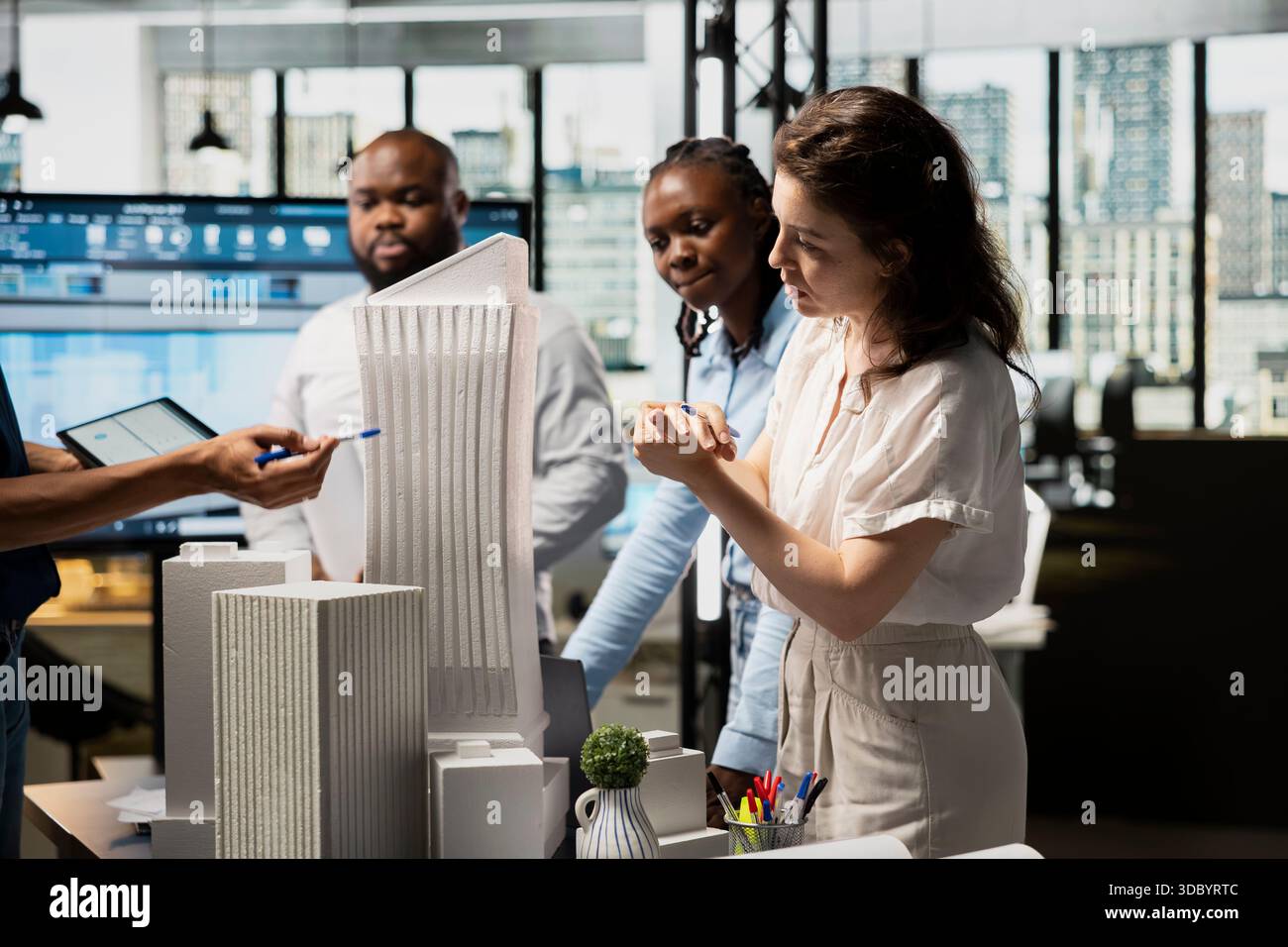 Real estate diverse experts studying 3D models and digital software for ...