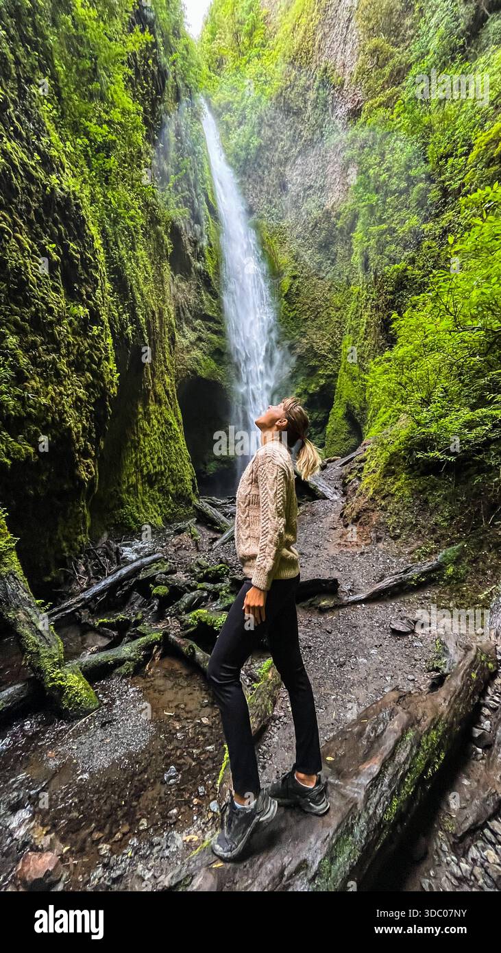 Woman poses in front of Salto Mili Mili near Coñaripe, Chile, aligning ...