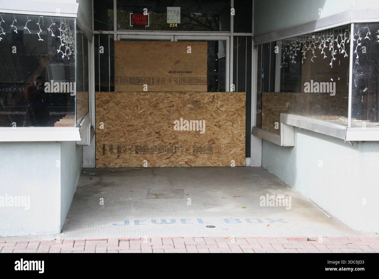 One of many empty storefronts is boarded up along a street in downtown ...