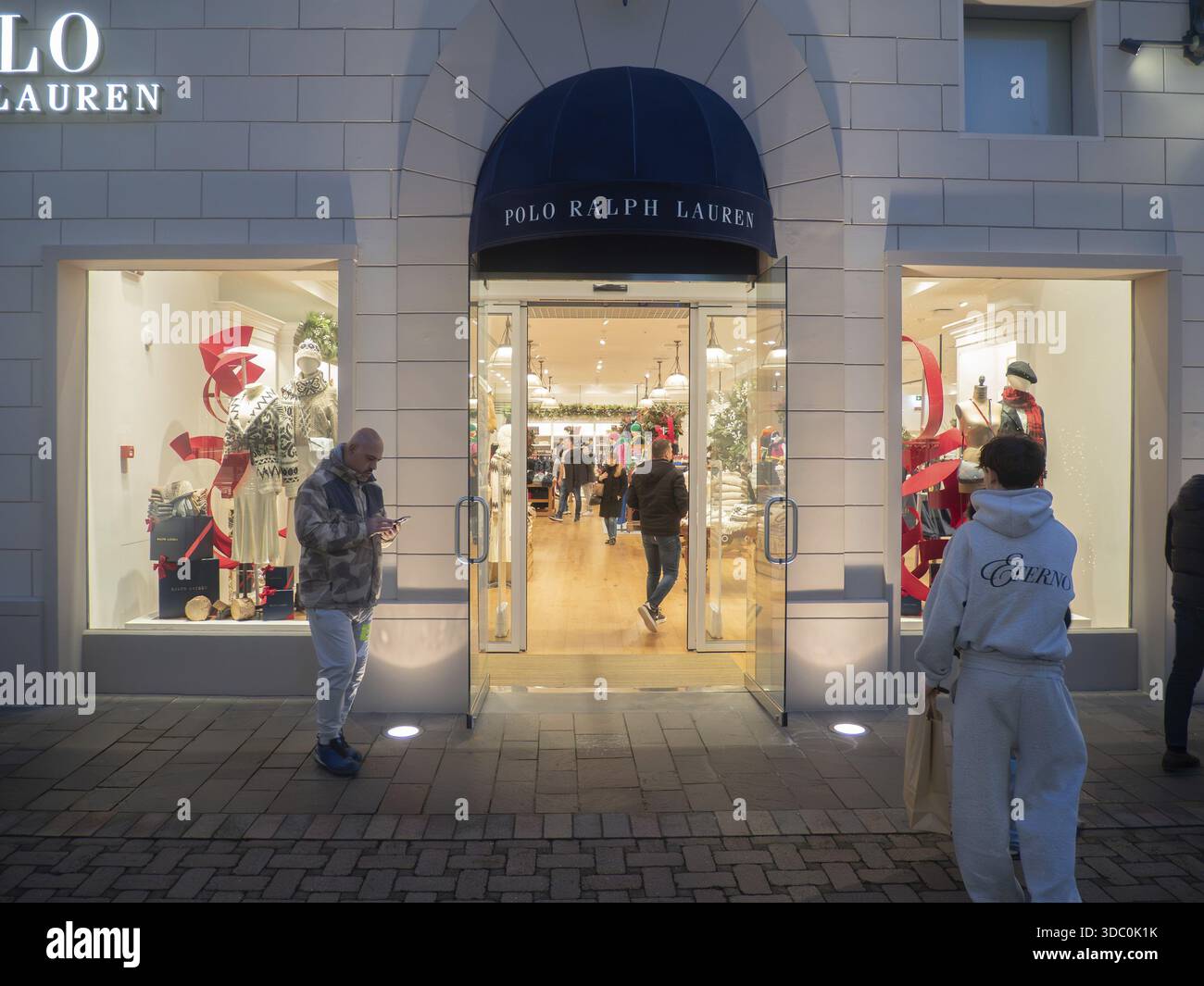 Polo Ralph Lauren store entrance with illuminated interior and shoppers ...