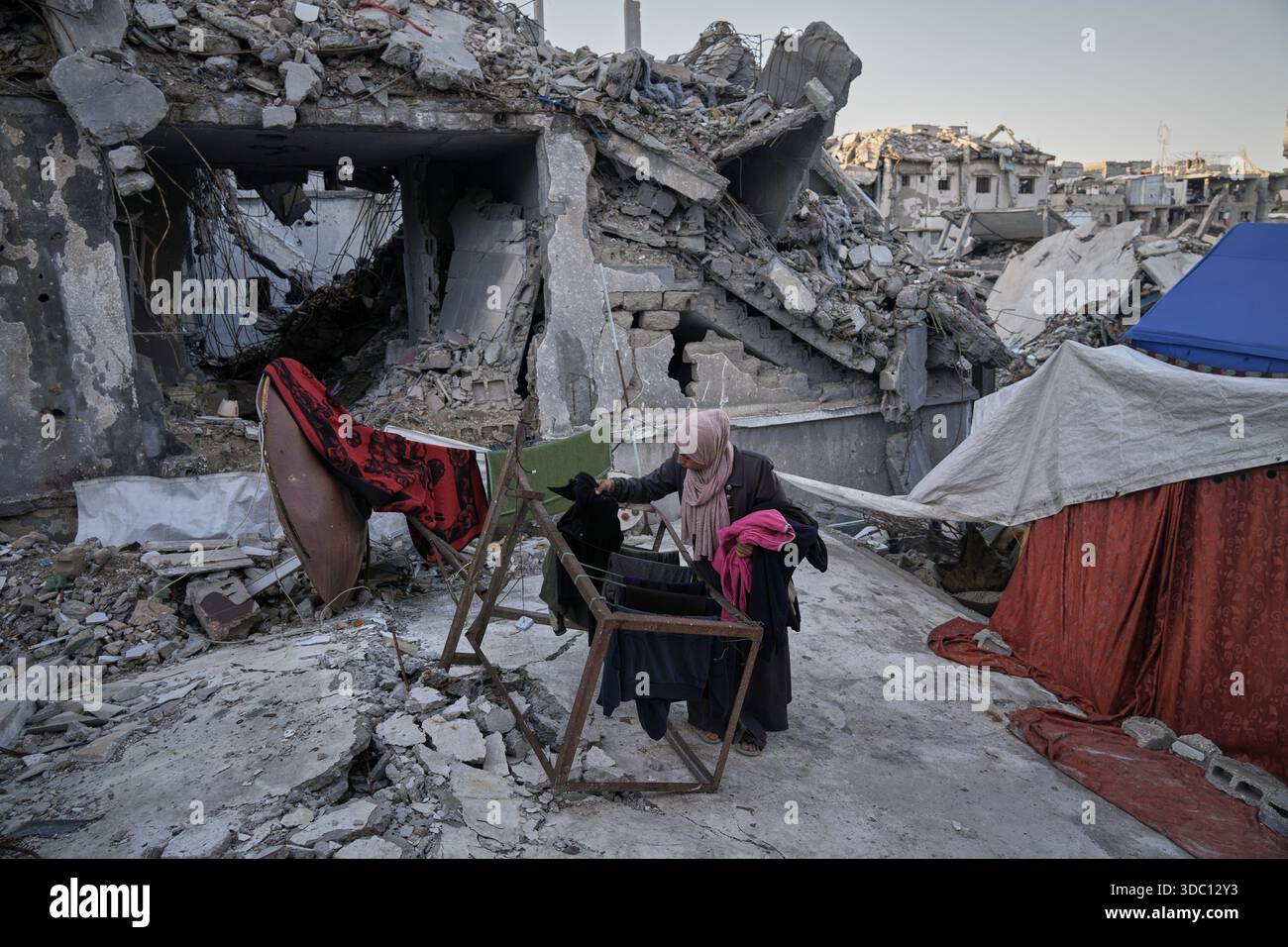 Saadia Abu Duheir, a mother of six, hangs laundry beside a tent set up ...