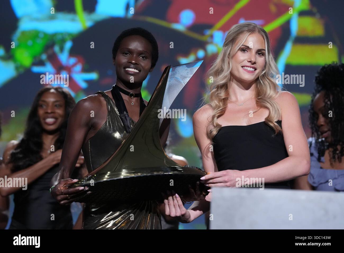 Parker Valby (left) presents Doris Lemngole of Alabama the Bowerman ...