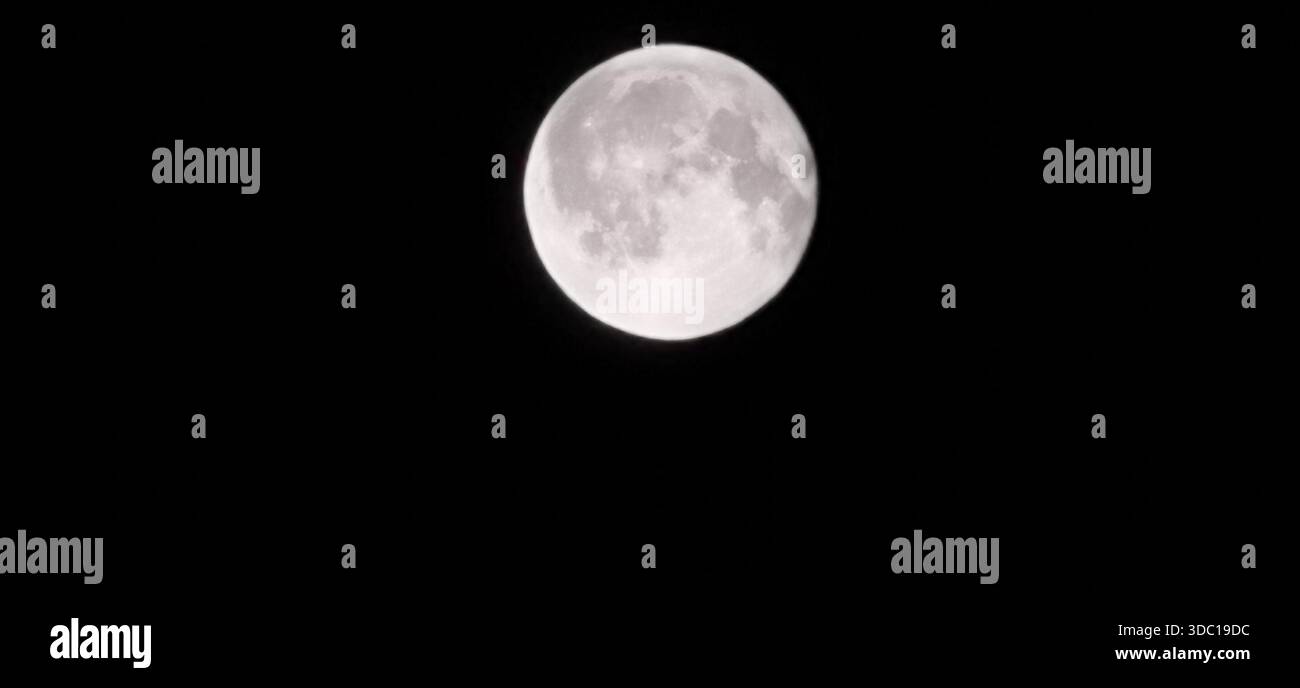 A stunning and bright full moon glowing against the deep darkness of ...
