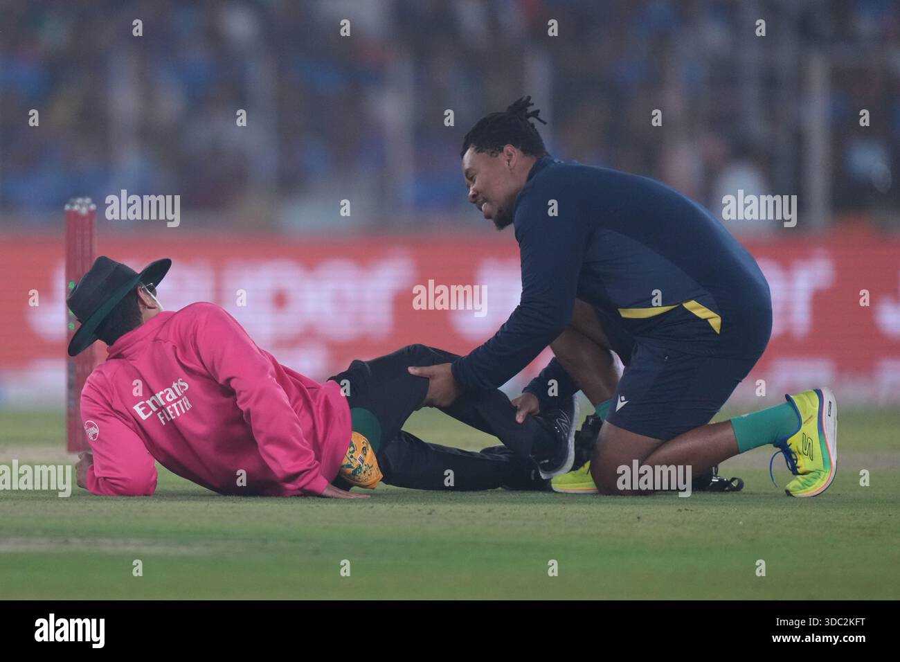 A physio, right, attend umpire Rohan Pandit hit by India's Sanju Samson ...