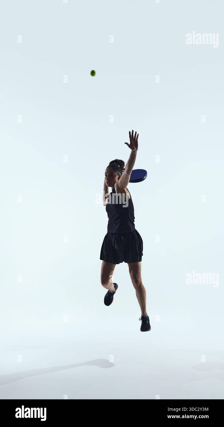 Female padel player jumping in studio and preparing overhead shot Stock ...