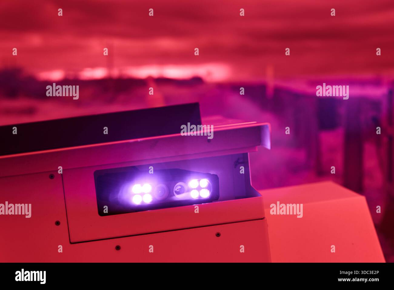 An infrared beam of light shines out of an automatic license plate ...