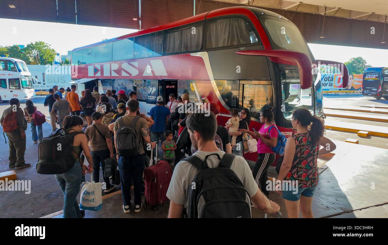 People boarding a red ersa bus at the platforms of the Terminal de ...