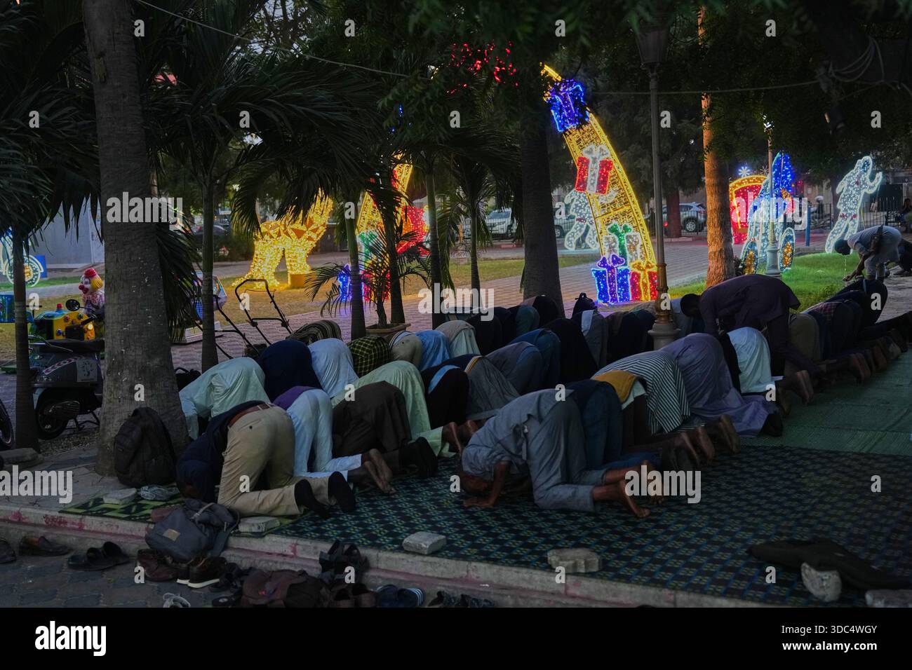 Muslims pray near a Christmas decoration in downtown Dakar, Senegal ...