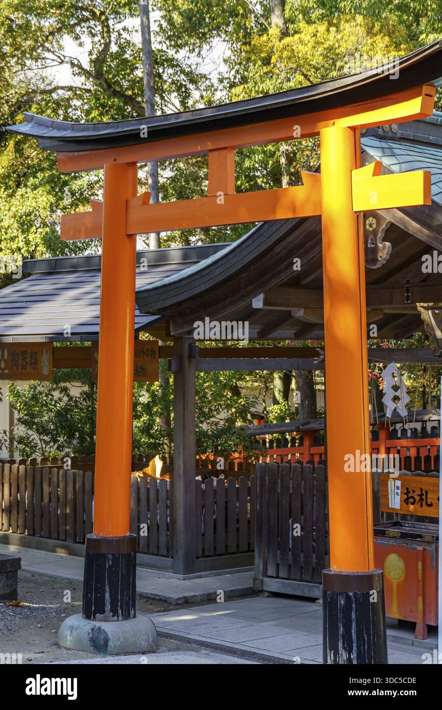 Orange torii arch in front of a traditional Japanese temple building ...