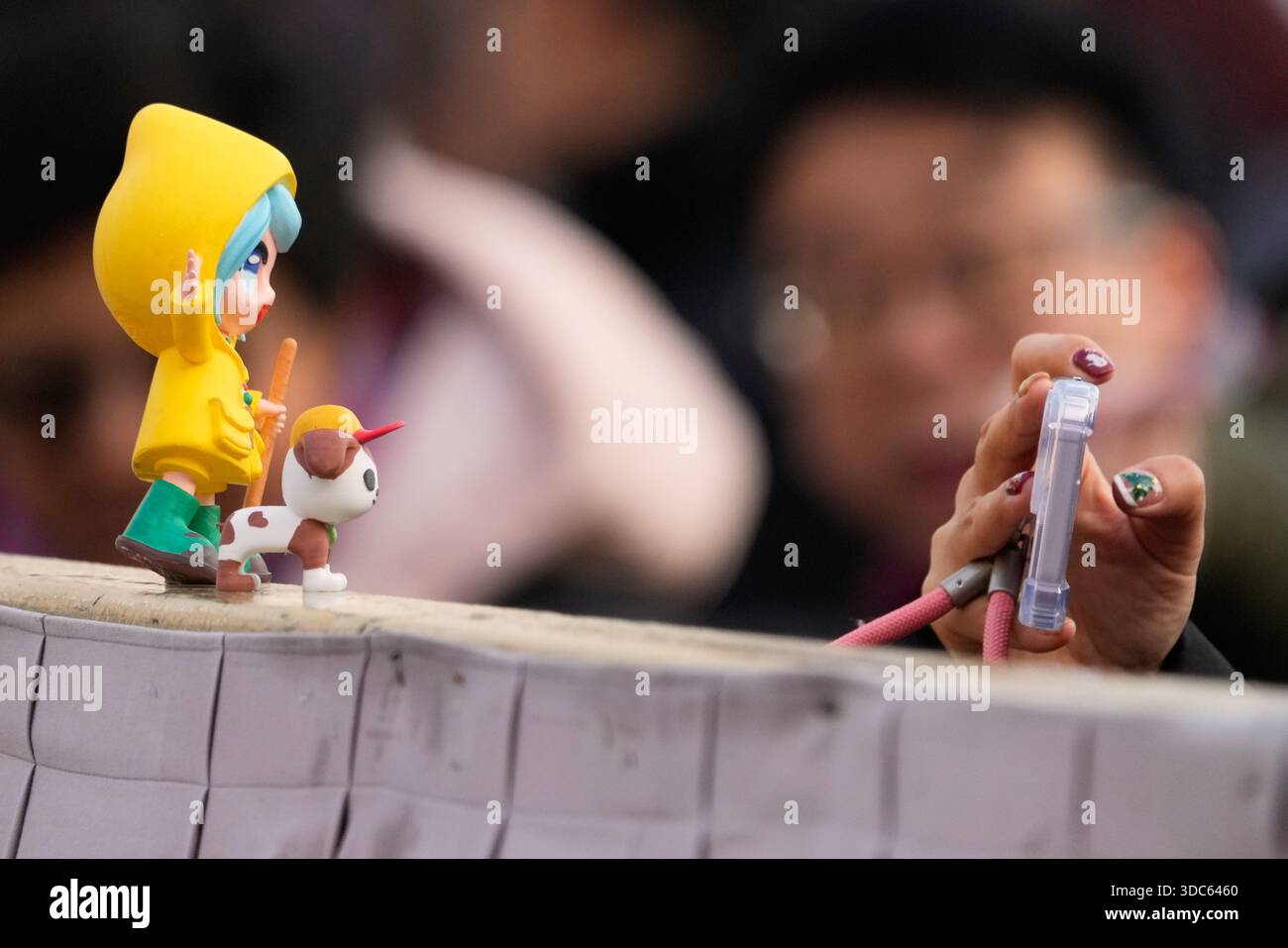 A woman takes a picture of the Jubilee mascot Luce as faithful wait for ...