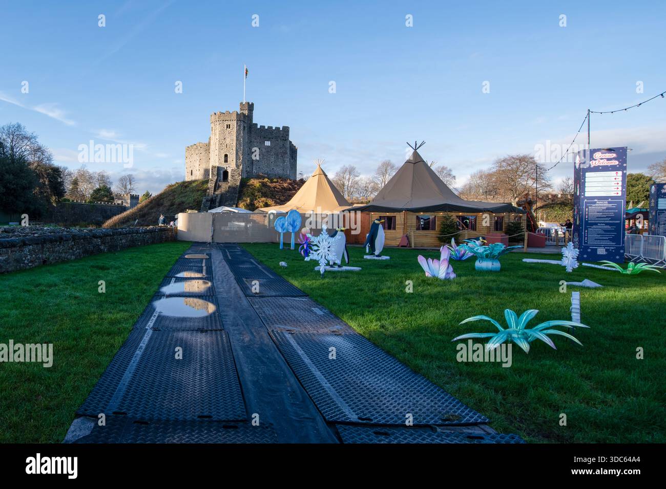 Medieval castle overlooking a winter event village with tents and ...