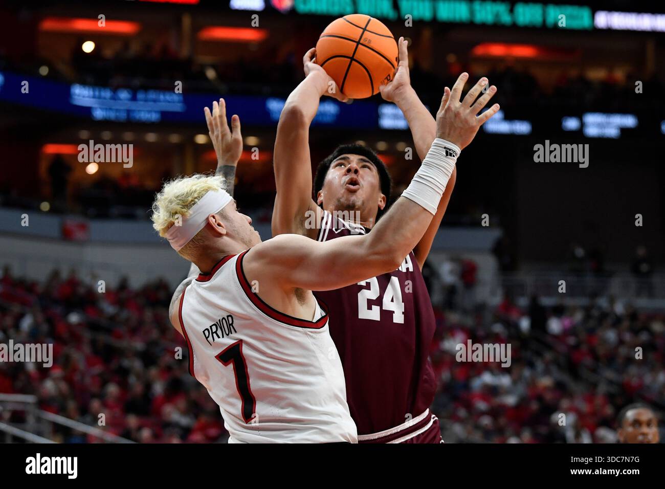 Montana forward Kenyon Aguino (24) shoots over Louisville forward ...