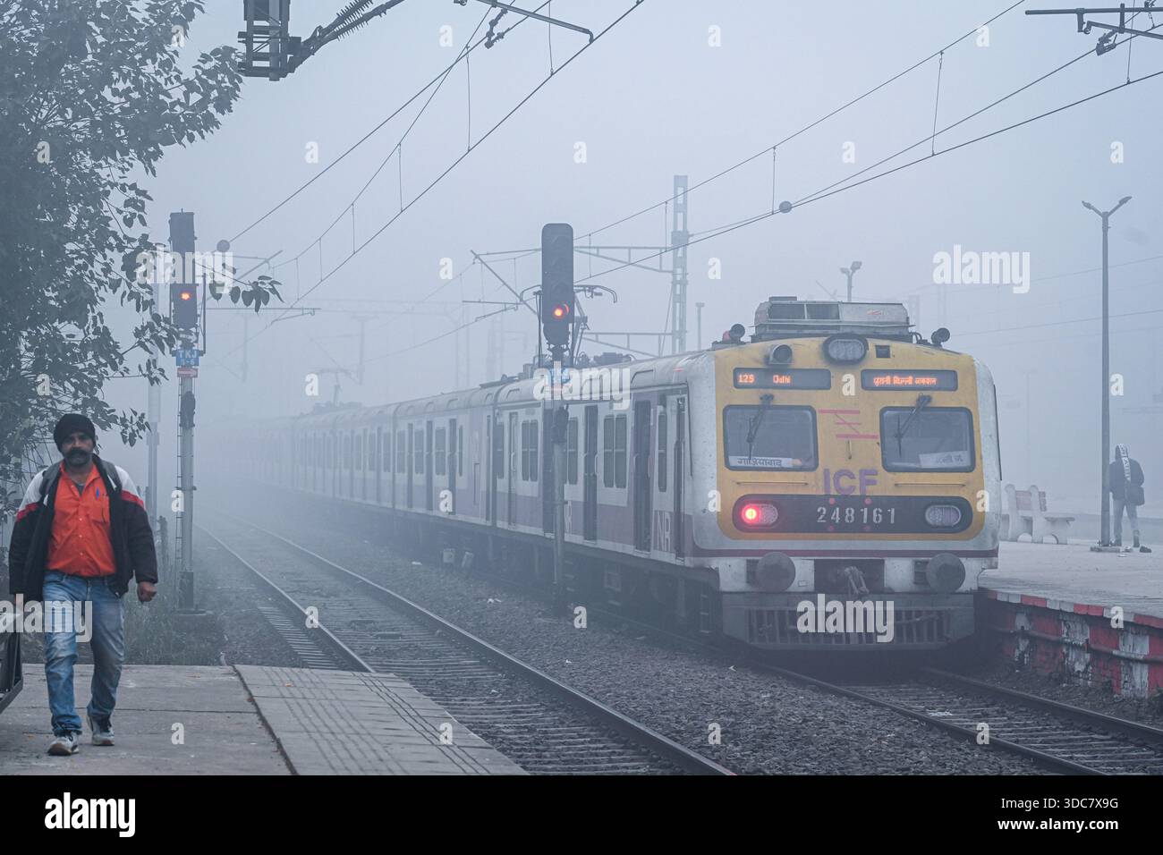 NEW DELHI, INDIA - DECEMBER 20: A passenger train moves through dense ...