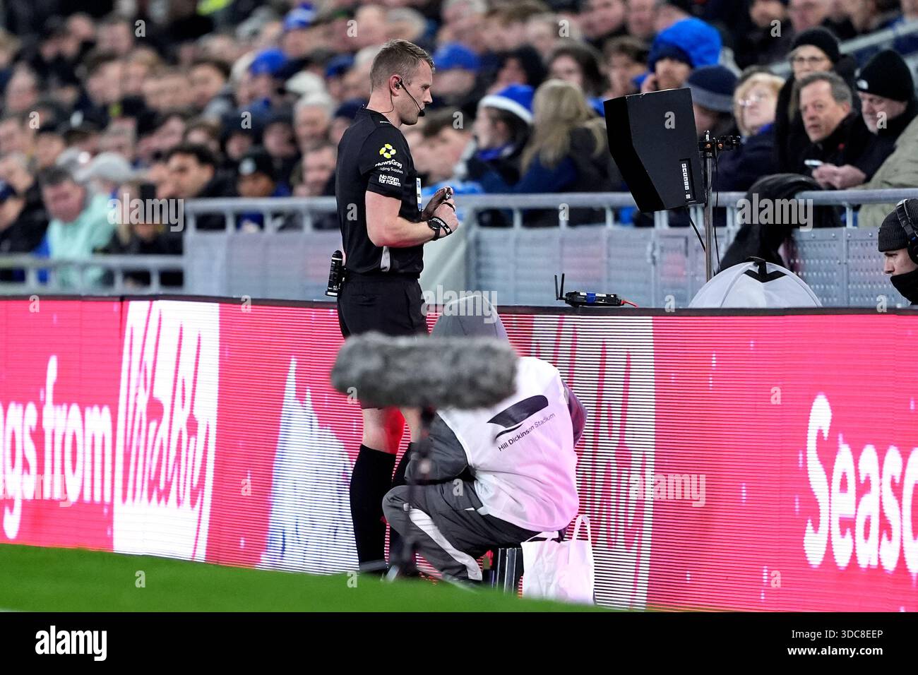 Referee Sam Barrott looks at the pitch side VAR screen before awarding ...
