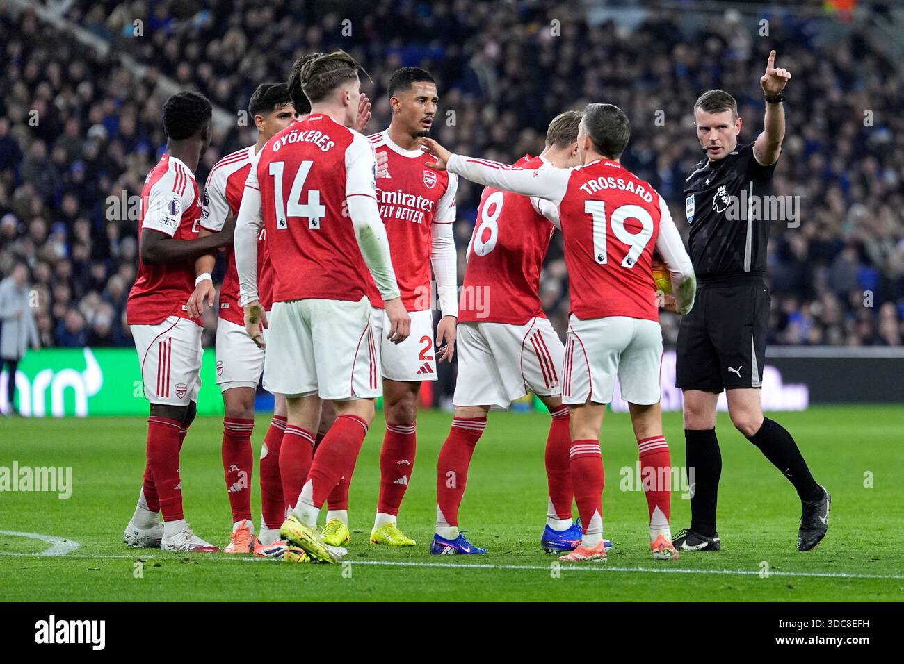 Arsenal players surround referee Sam Barrott during the Premier League ...