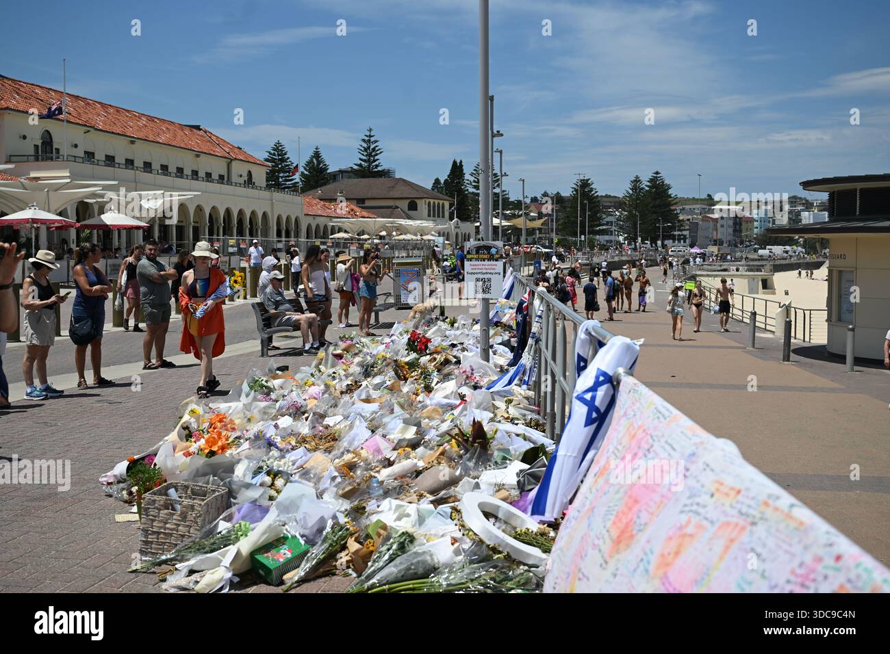 People continue to bring flowers to the Bondi Beach promenade as crowds ...
