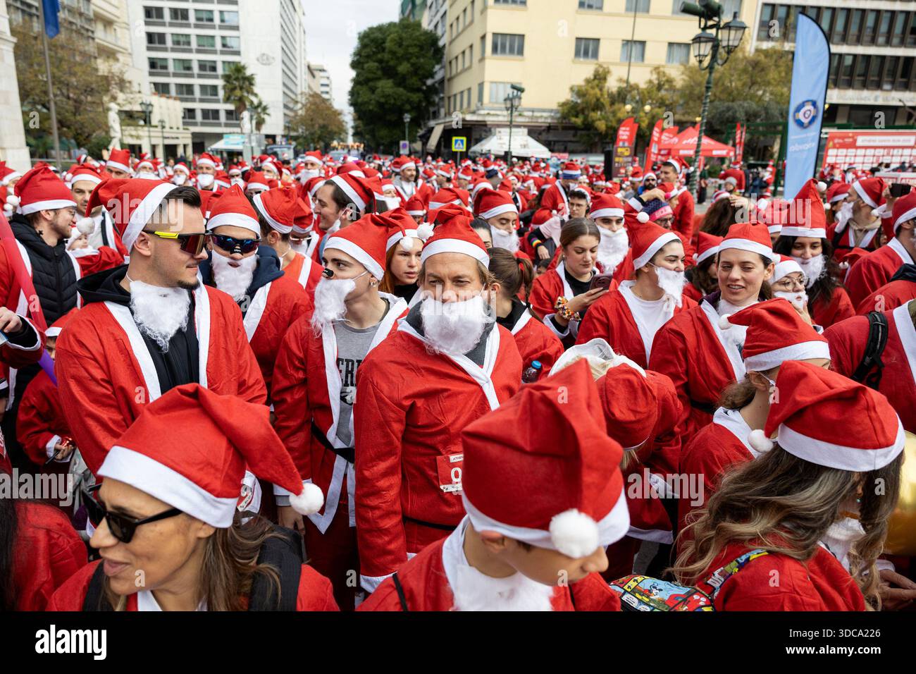 People wearing Santa Claus costumes wait at the start line of the ...
