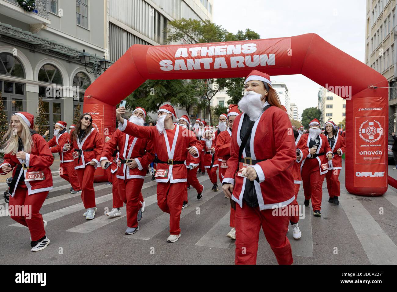People wearing Santa Claus costumes participate in the Athens Santa Run ...