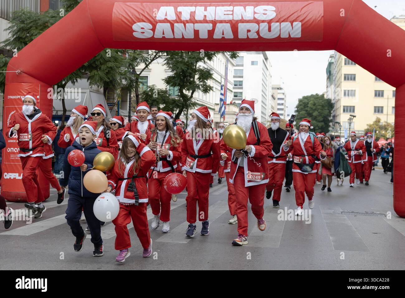 People wearing Santa Claus costumes participate in the Athens Santa Run ...