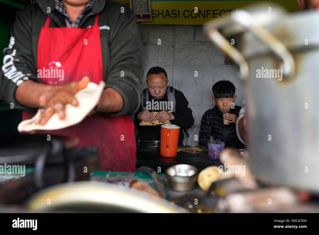 Sonam Tashi and his son, Kunga Tenzin, eat breakfast at a roadside ...