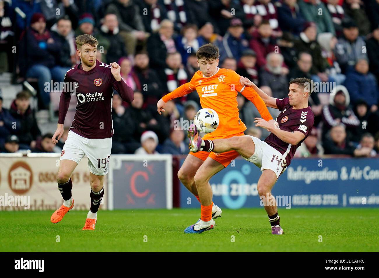 Rangers' Mikey Moore (centre) battles for the ball with Heart of ...