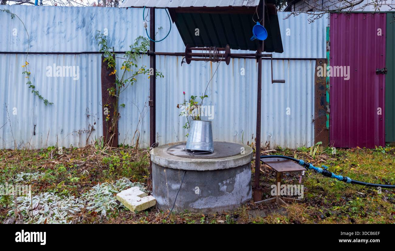 Old rural water well structure with bucket Stock Photo - Alamy